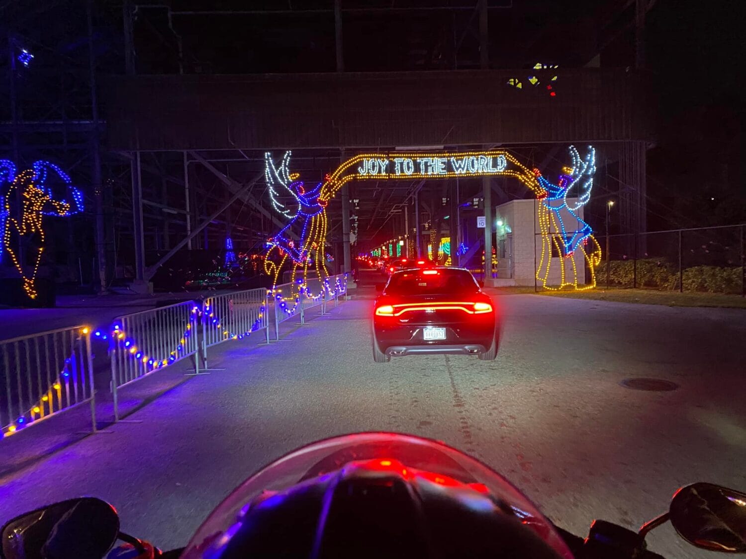 A view from a rider passing through a display of holiday lights