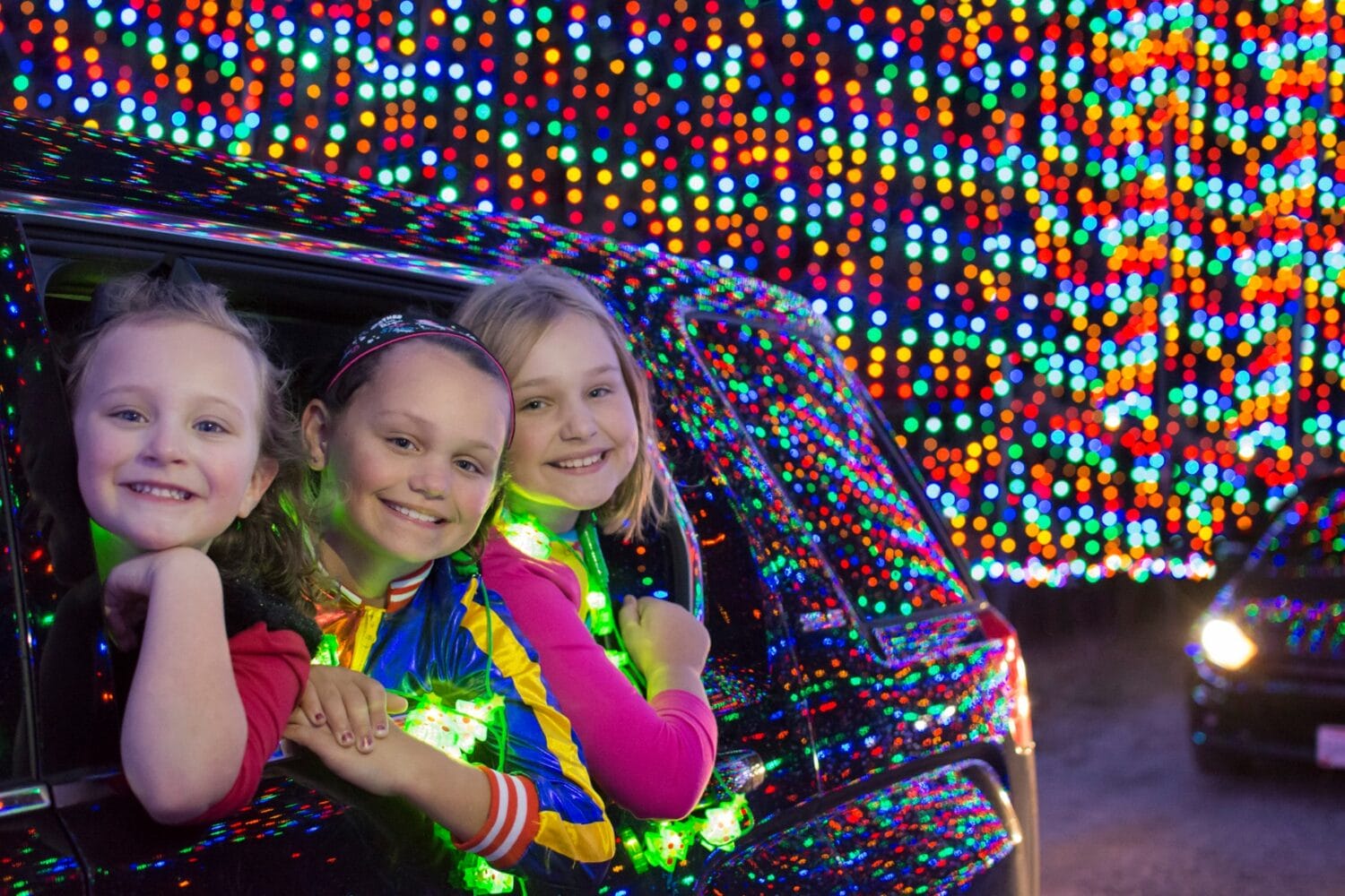 Children enjoying a magical ride through the vibrant holiday lights
