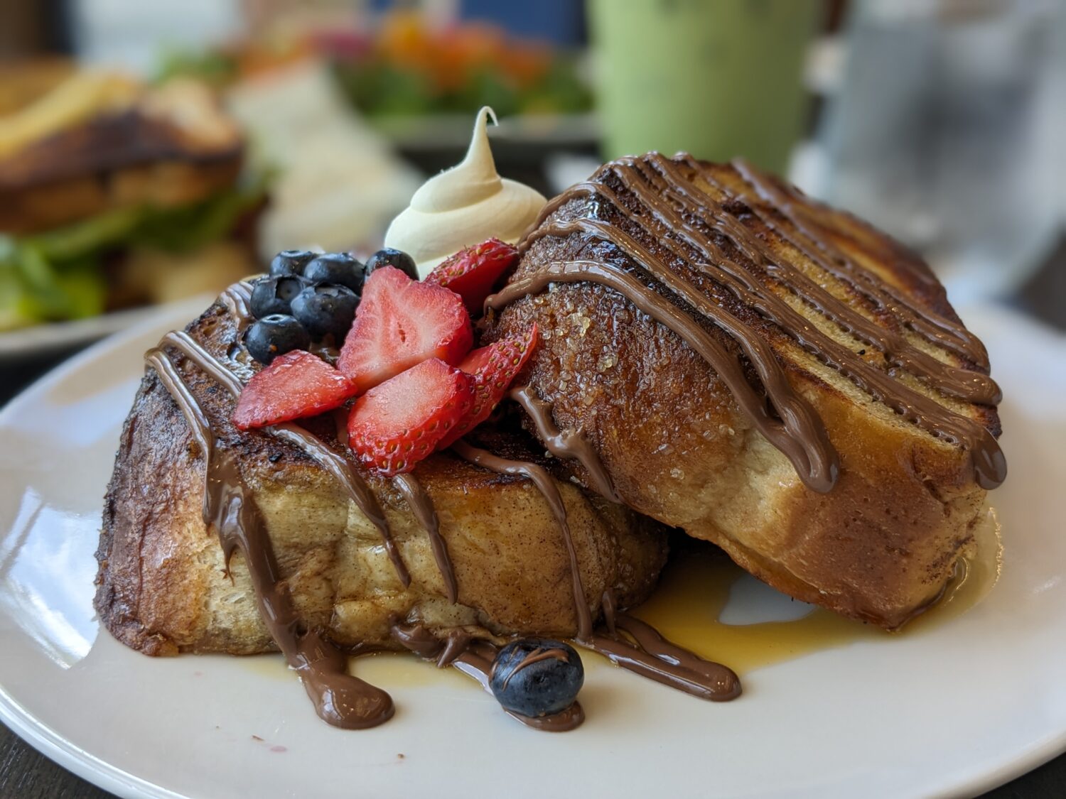 a plate of french toast stack with fresh berries and a drizzle of maple syrup