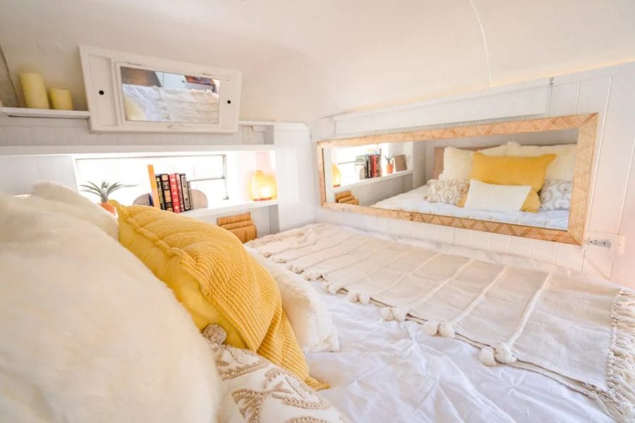 A cozy bed with white and yellow accent.