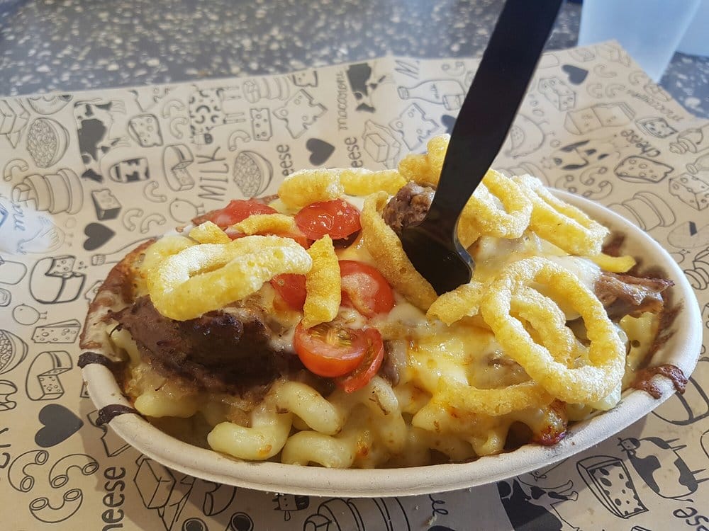 a bowl of heaping mac and cheese with various toppings