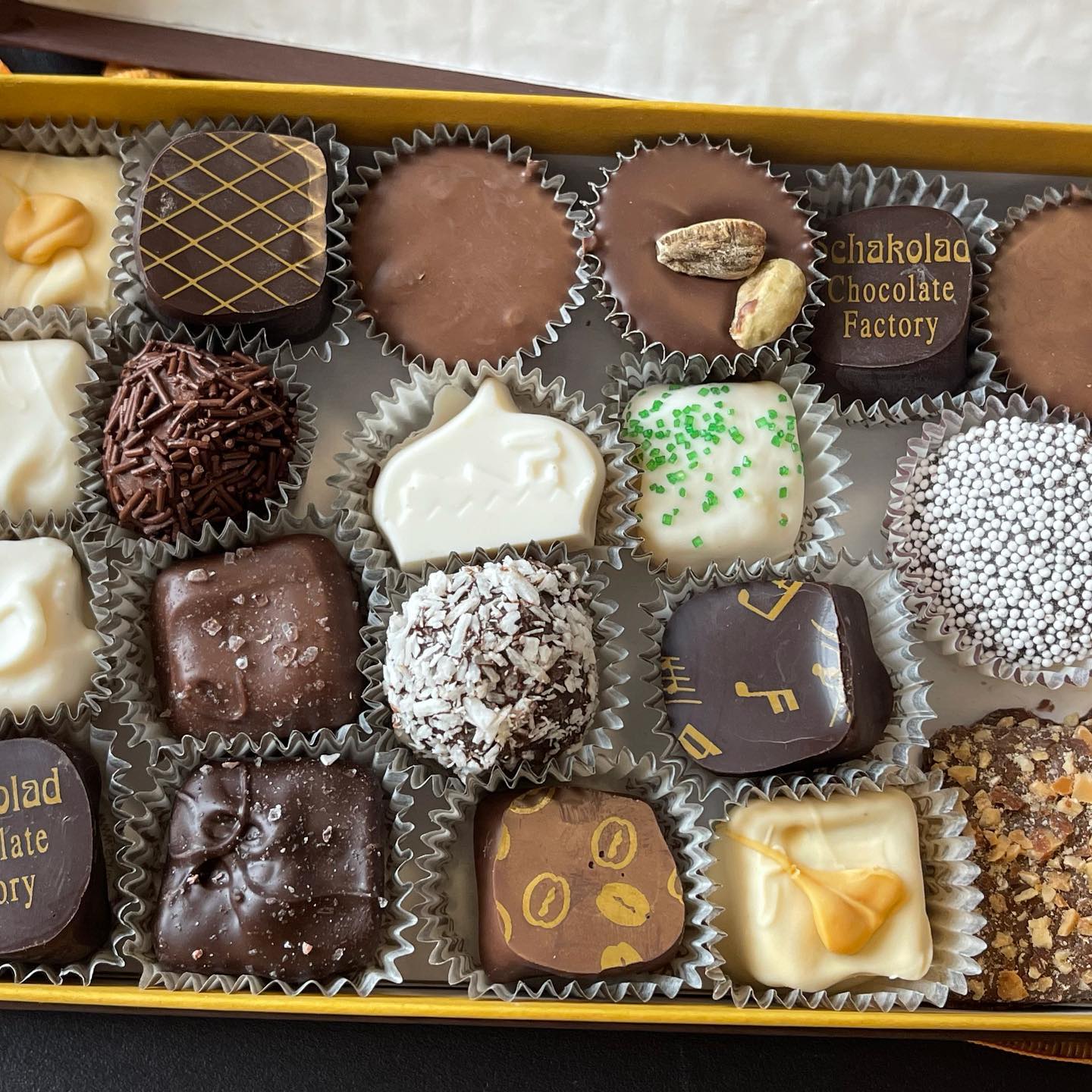 A box of crafted chocolates with different designs and flavors