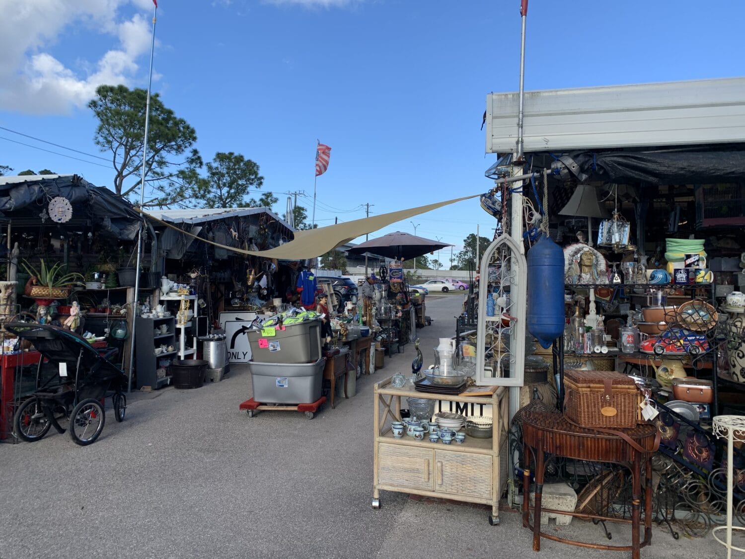 a bustling outdoor flea market with an eclectic array of items on display under a bright sky