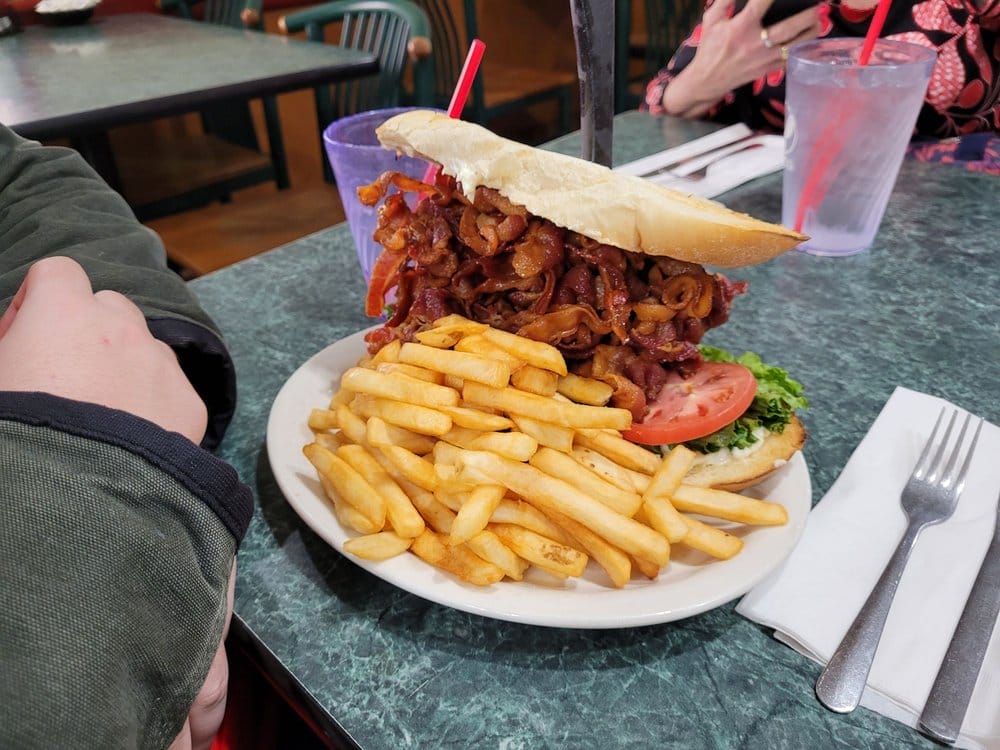 a classic blt sandwich loaded with bacon alongside a portion of fries