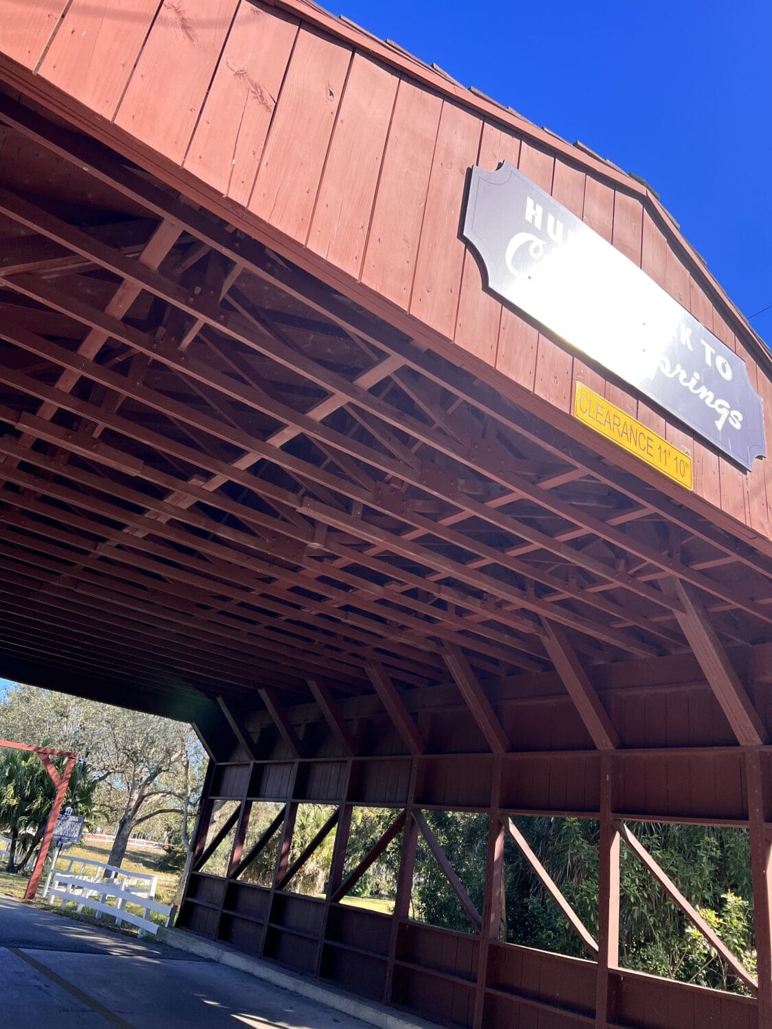 a close up look of the bridge made of a single steel span and a roof composed of 25 truss rafters