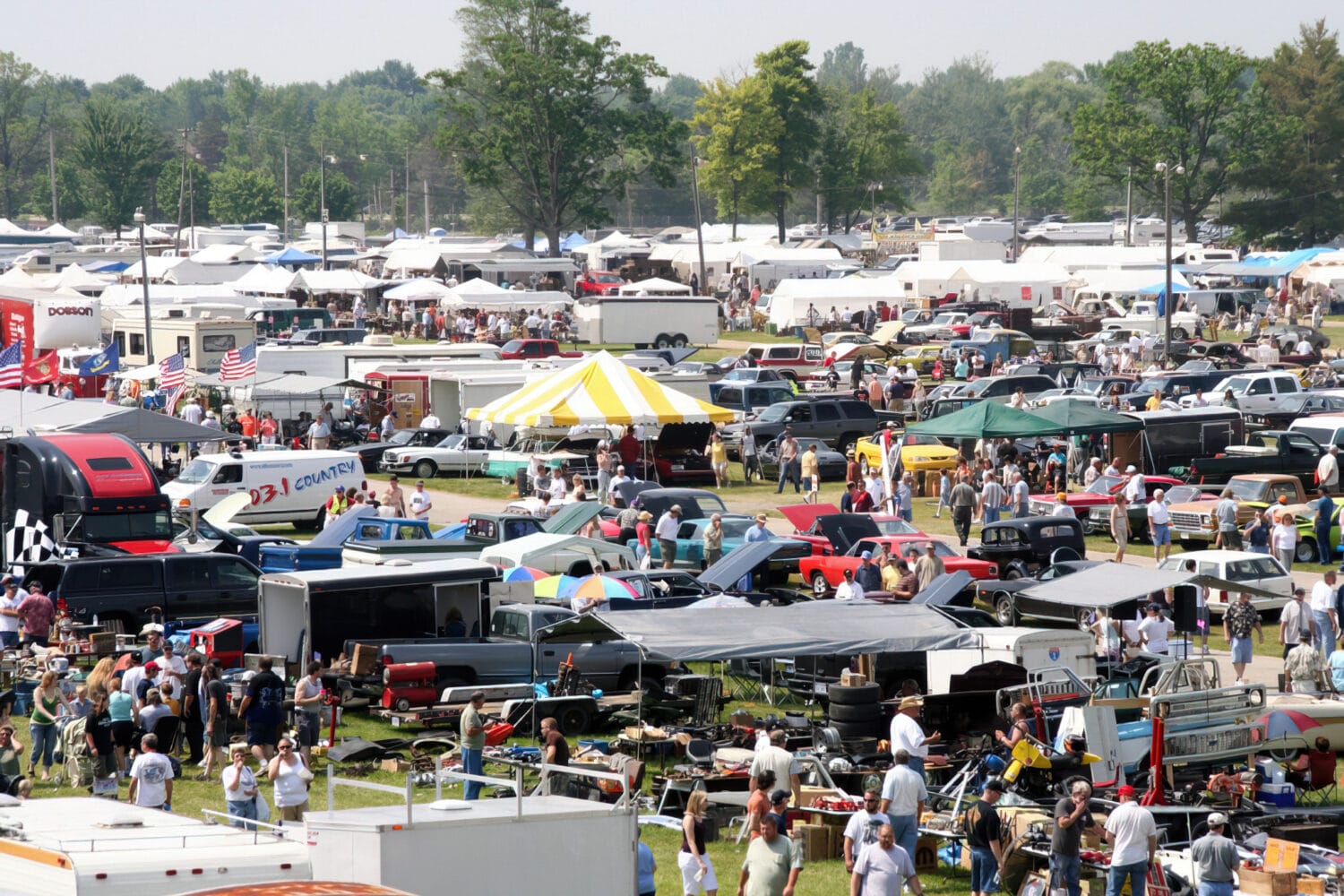 a crowded flea market with numerous tents and people searching for finds amongst a sea of antiques and collectibles