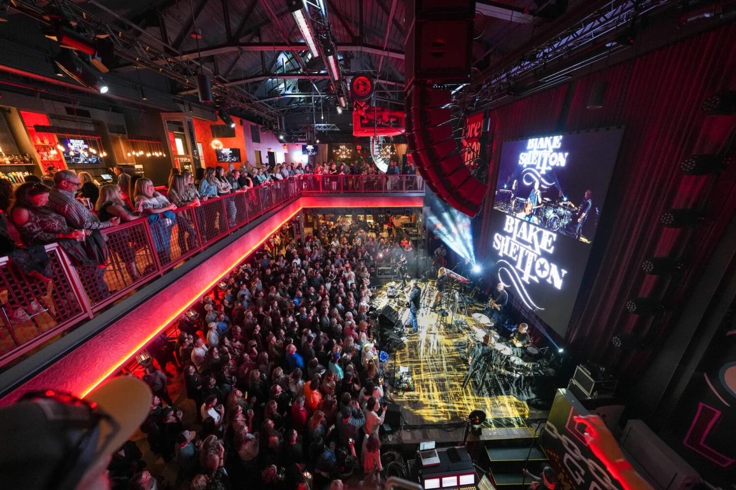 a huge crowd inside the ole red orlando restaurant with blake shelton performing on stage