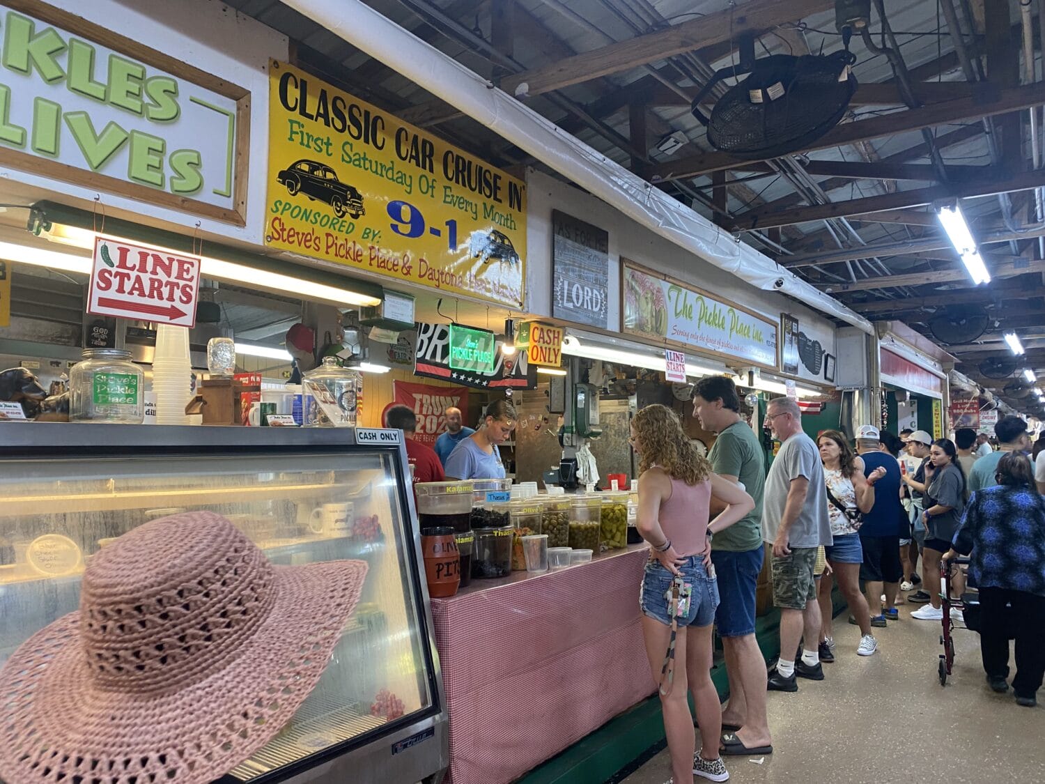 a line of food stalls inside the market with people buying their foods