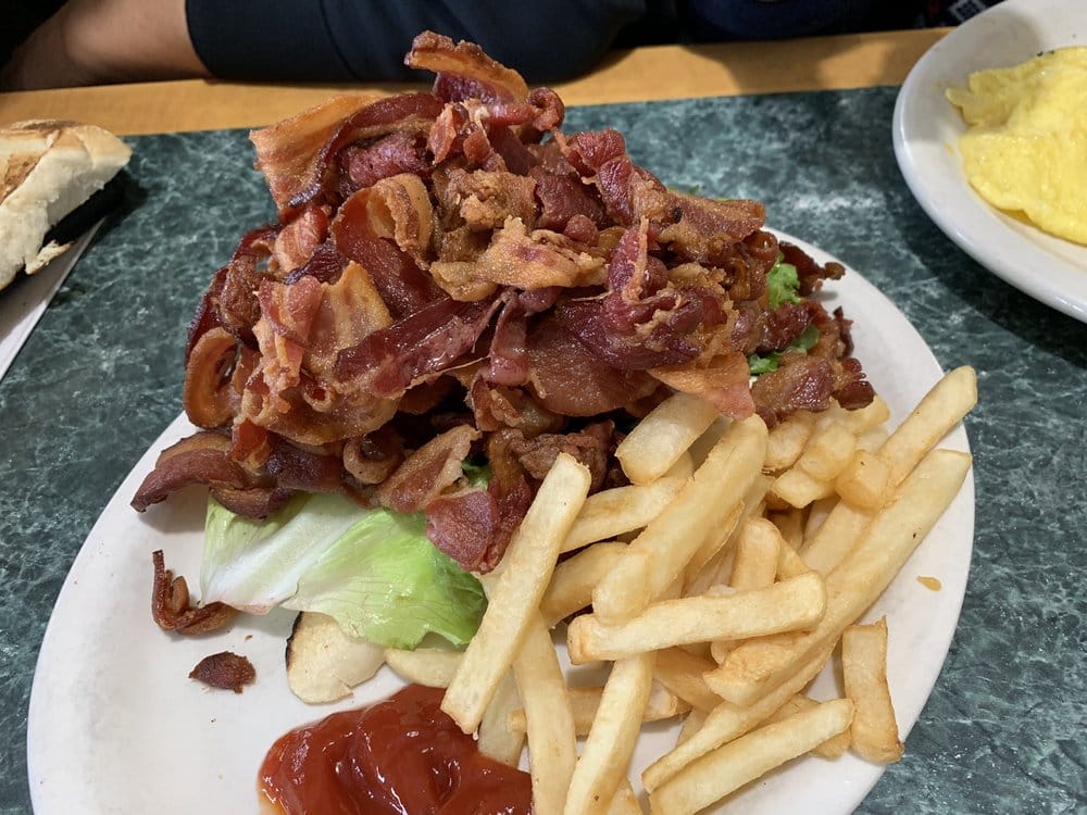 A mountainous serving of crispy bacon and by fries.