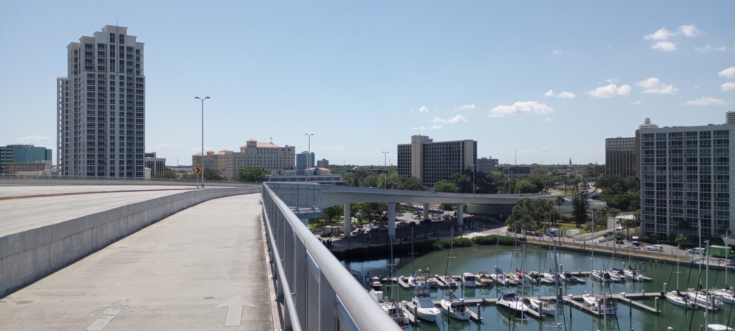 a photo of the bike trail on the bridge with view of the marina below it