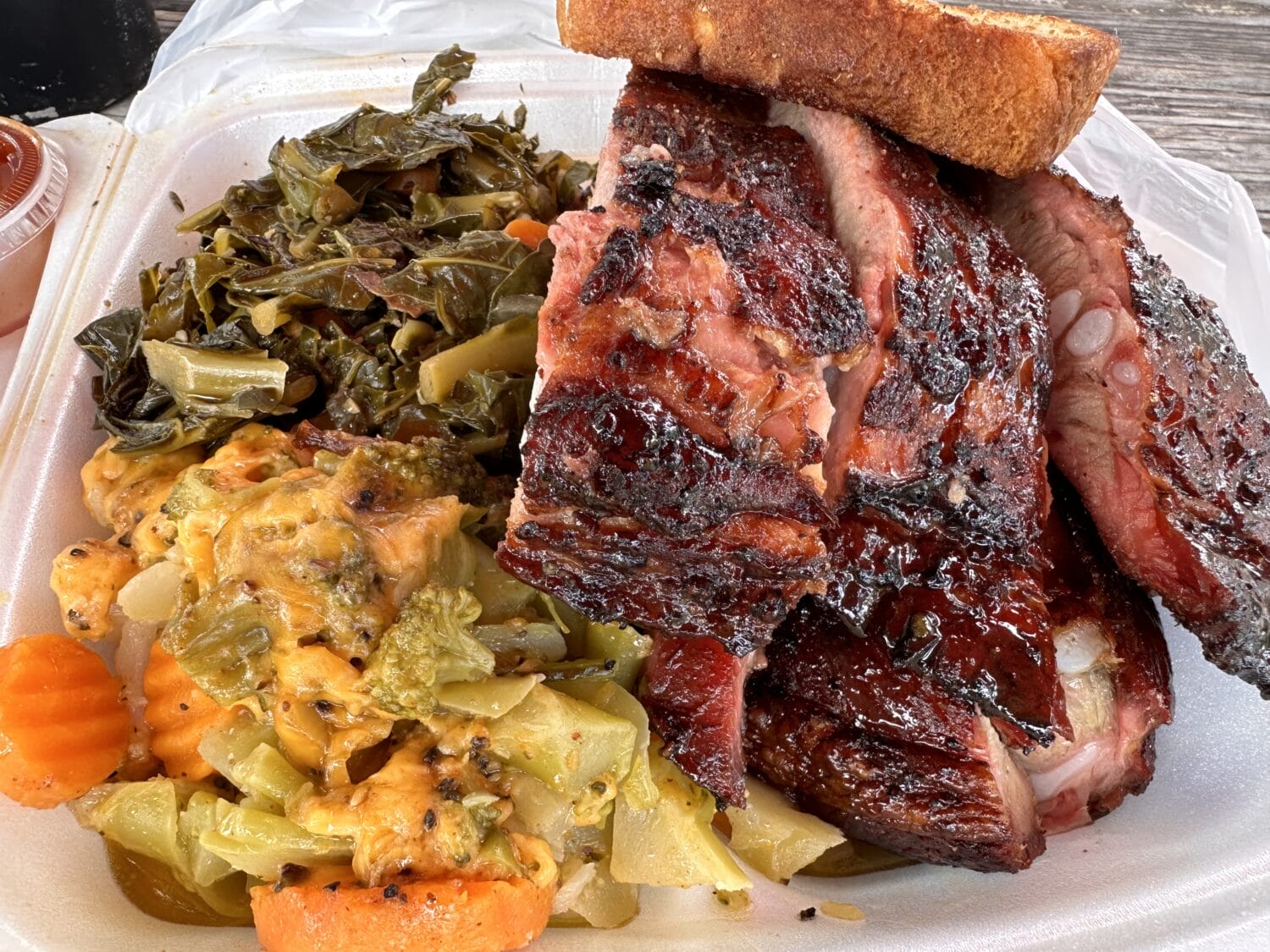 A plate of juicy barbecue with various sides served at Pearl Country Store & Barbecue