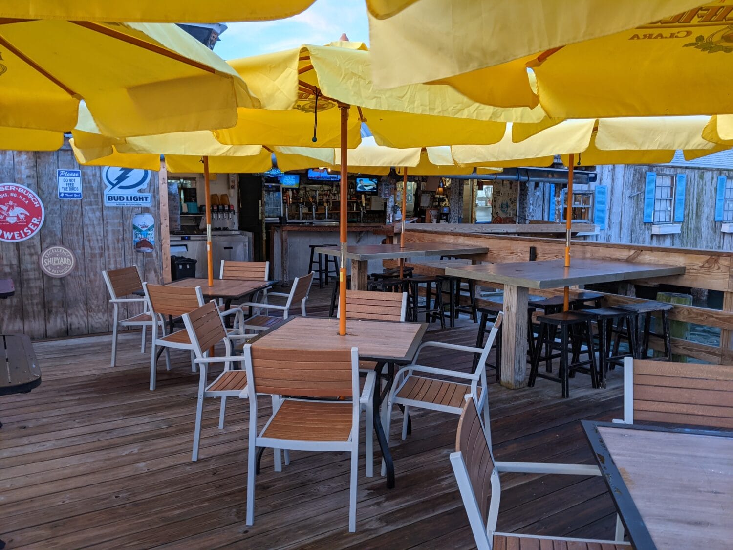 a quiet outdoor restaurant patio with empty tables under yellow umbrellas offering a relaxed dining atmosphere