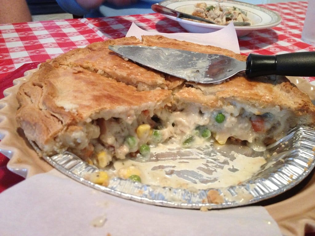 a savory chicken pot pie sliced to pieces and oozing in creaminess