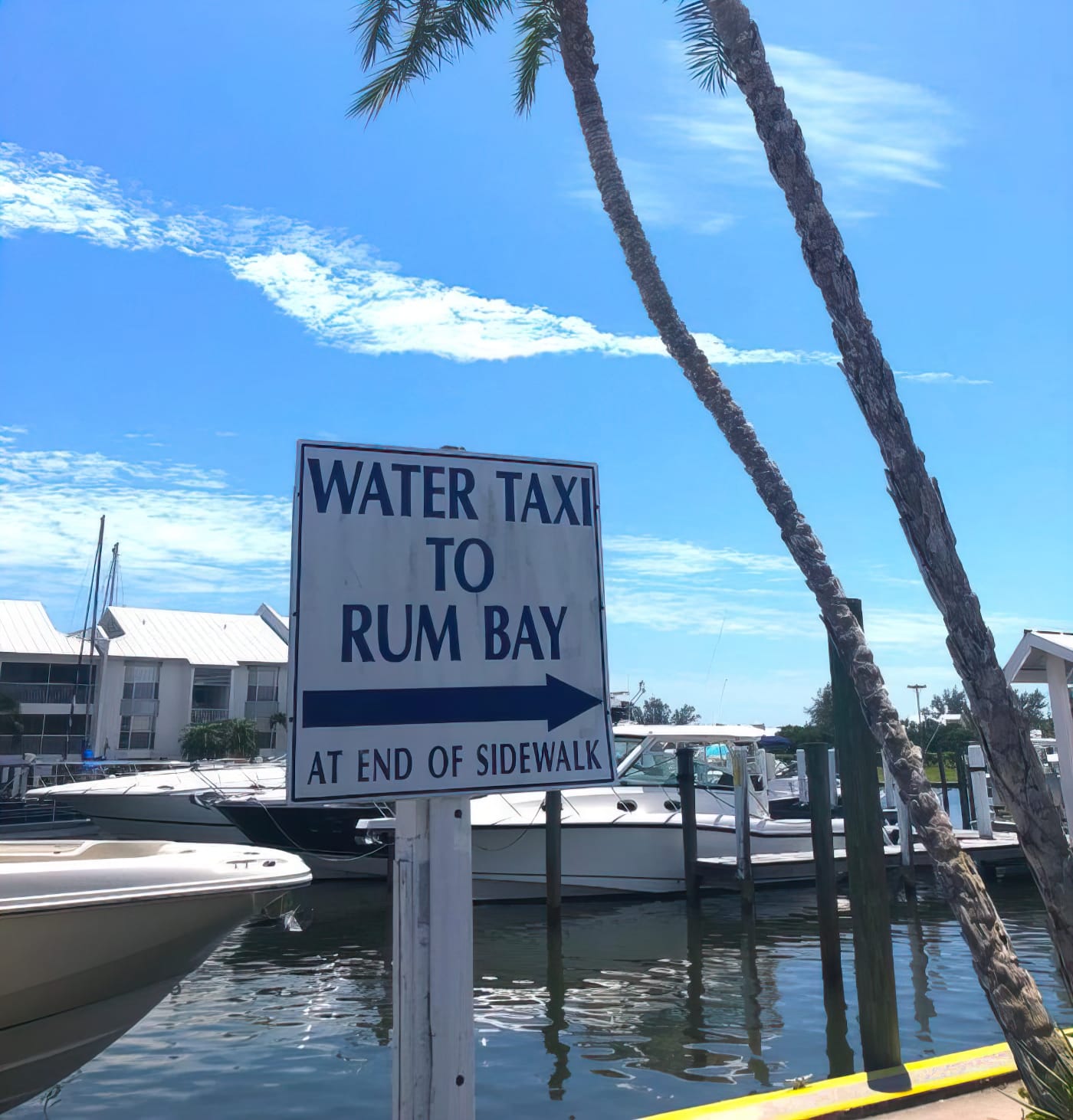 a sign indicating the direction and location of the water taxi to rum bay