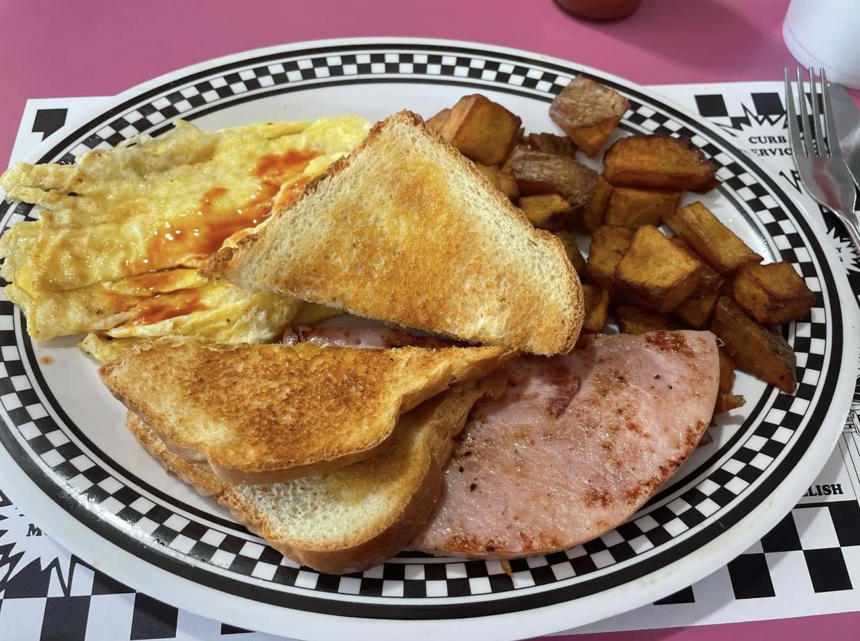 a traditional american breakfast plate with scrambled eggs ham hash browns and toast served at angels diner