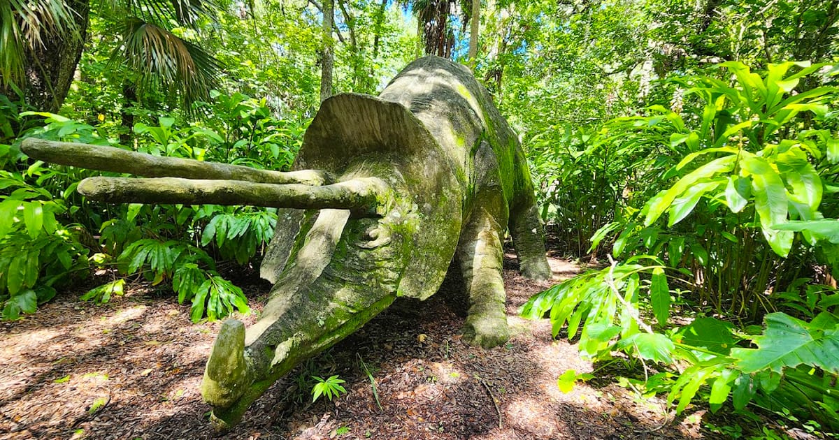 an image of a dino statue in the park