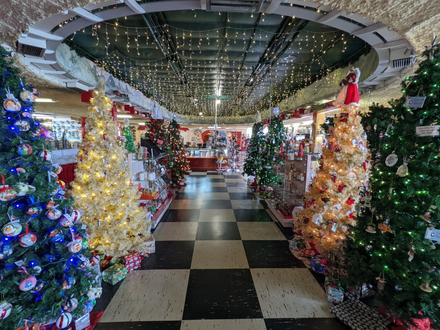 an indoor display featuring a variety of decorated christmas trees and festive lights likely within a holiday themed store