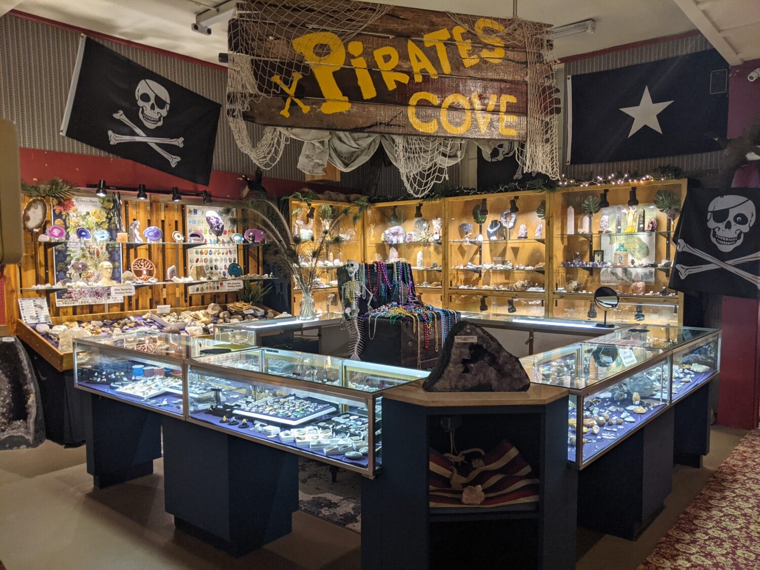 an interior view of a rock shop with a pirate theme featuring display cases of various stones and jewelry