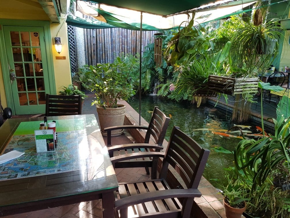 An outdoor dining area with a Koi pond