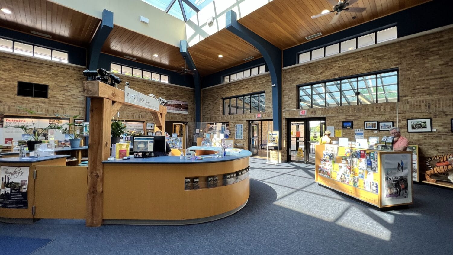 bright and spacious visitor center interior with a wooden welcome desk and informational brochures
