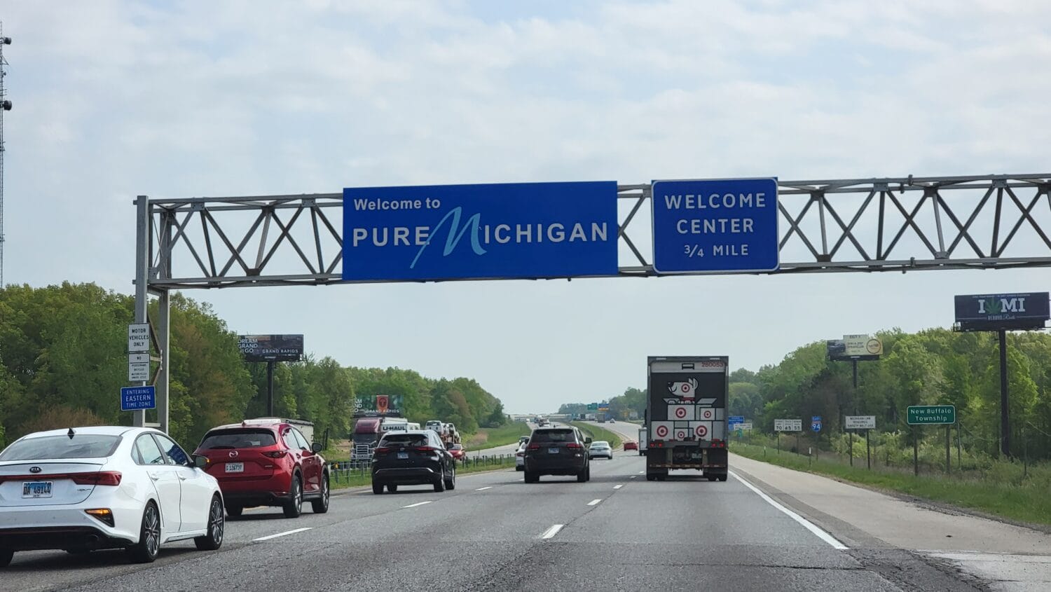 Cars driving along the highway with the scenic Welcome to Michigan sign