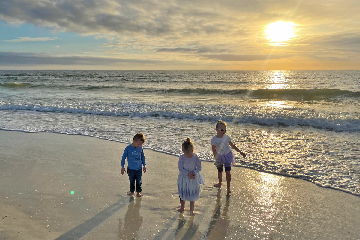 Children enjoying the beach at St. Joseph Peninsula State Park during sunset