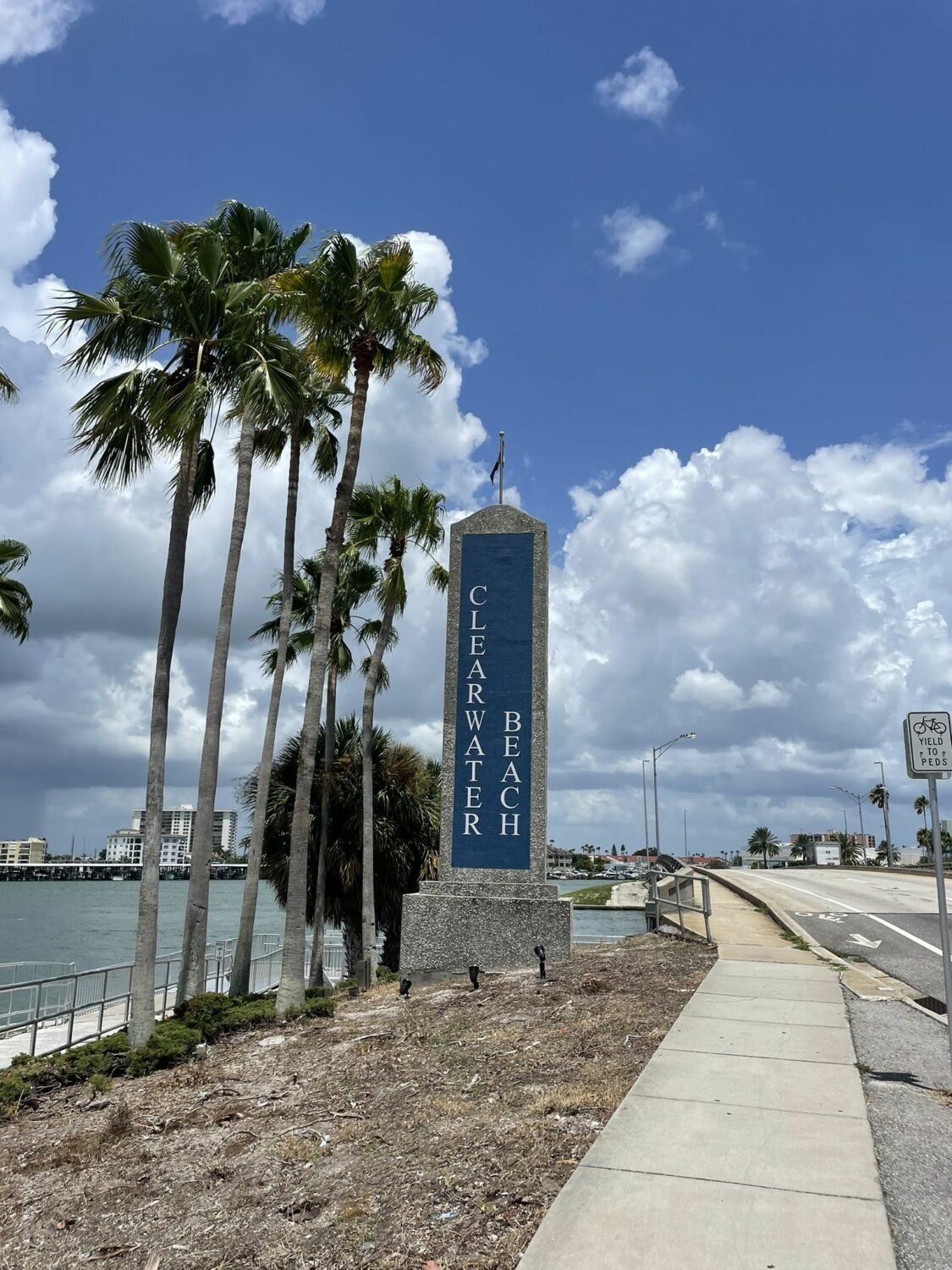 clearwater beach stone sign with views of the water and the trail ahead