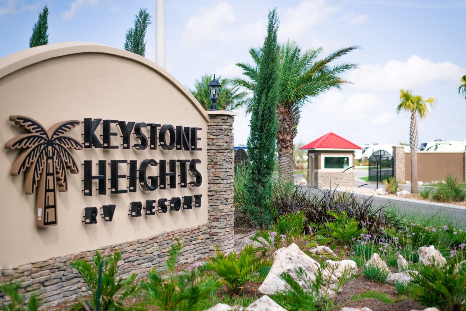 entrance sign of keystone heights rv resort with landscaping and palm trees