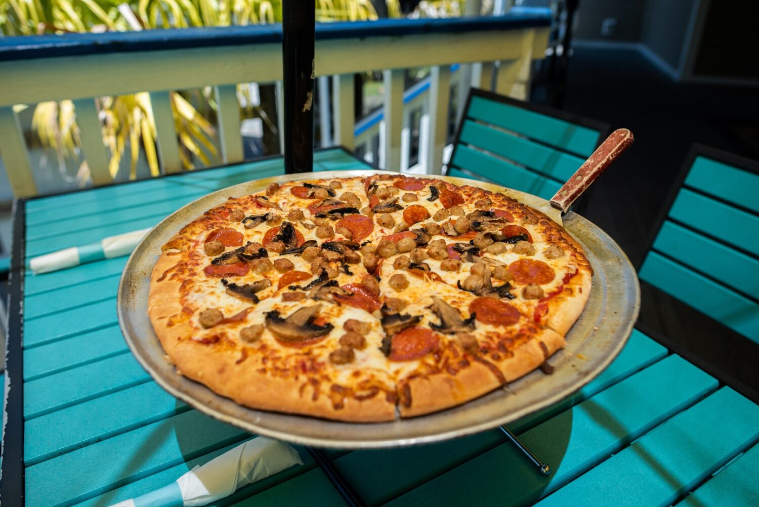freshly baked thin crust pepperoni pizza with green peppers and mushrooms