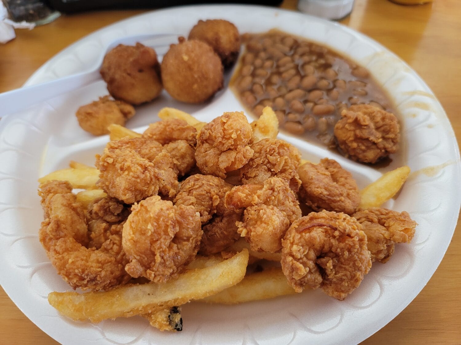 fried shrimp with fries baked beans and hush puppies