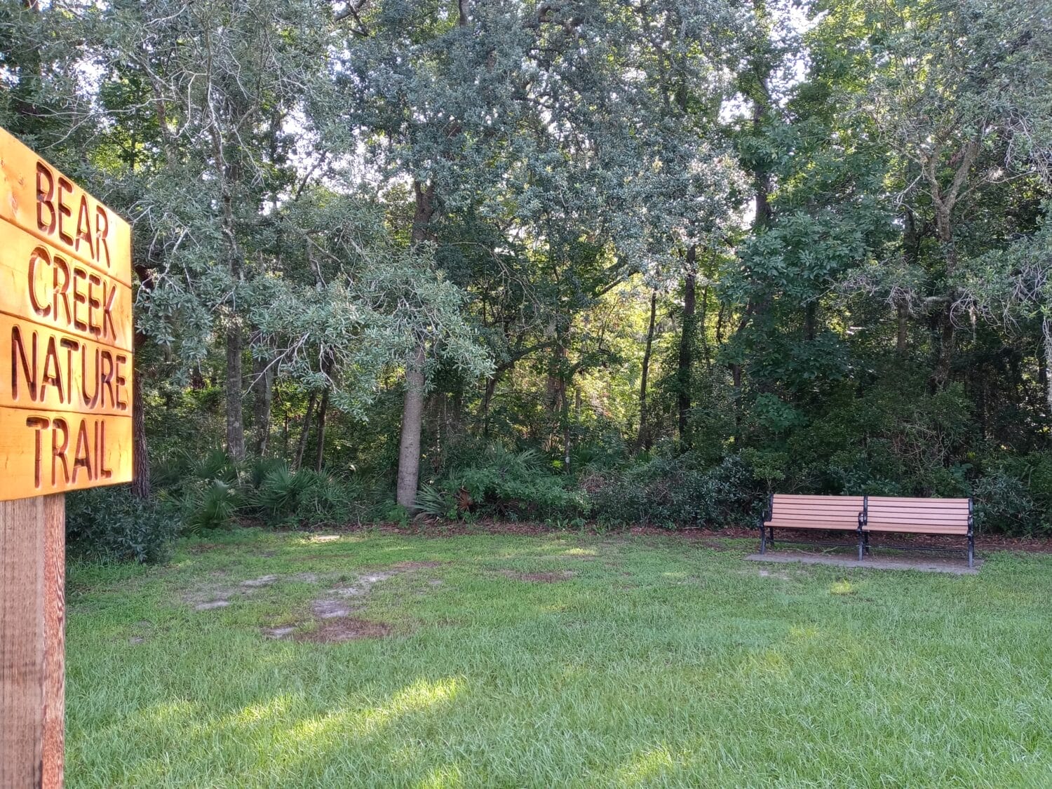 mini park along the trail with one bench and a signage