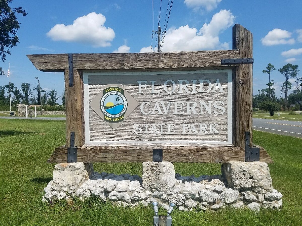 signage at the entrance of florida caverns state park featuring the parks name and emblem