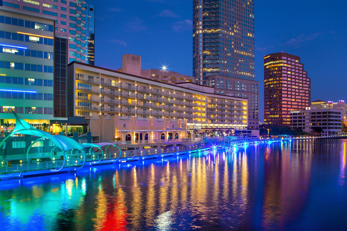 The Tampa Riverwalk at night lit with colorful lights