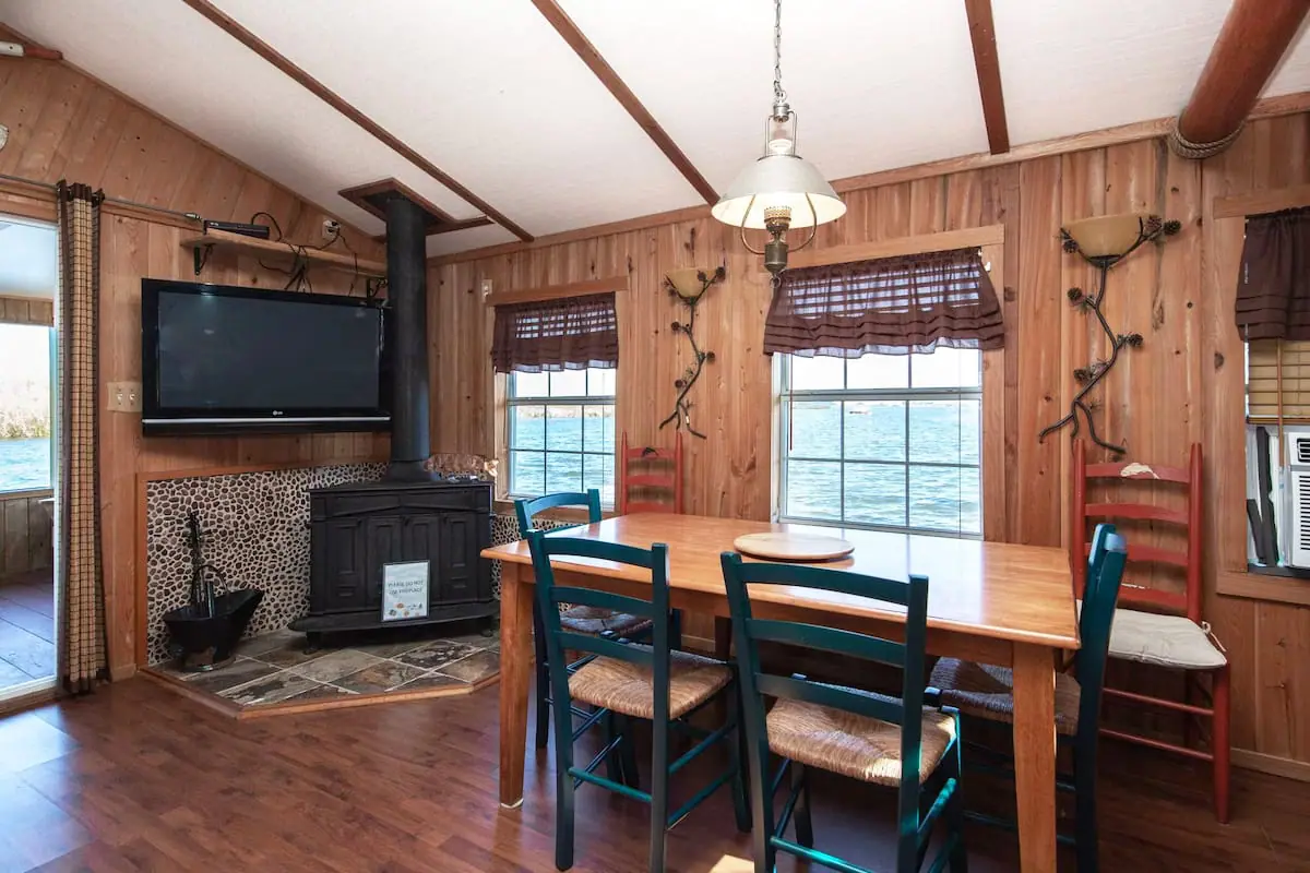 the dining area with a large tv and a fire place