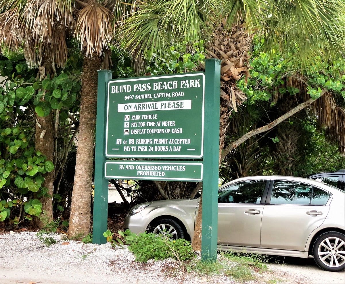 the entrance sign to blind pass beach park with information on parking and beach access guidelines
