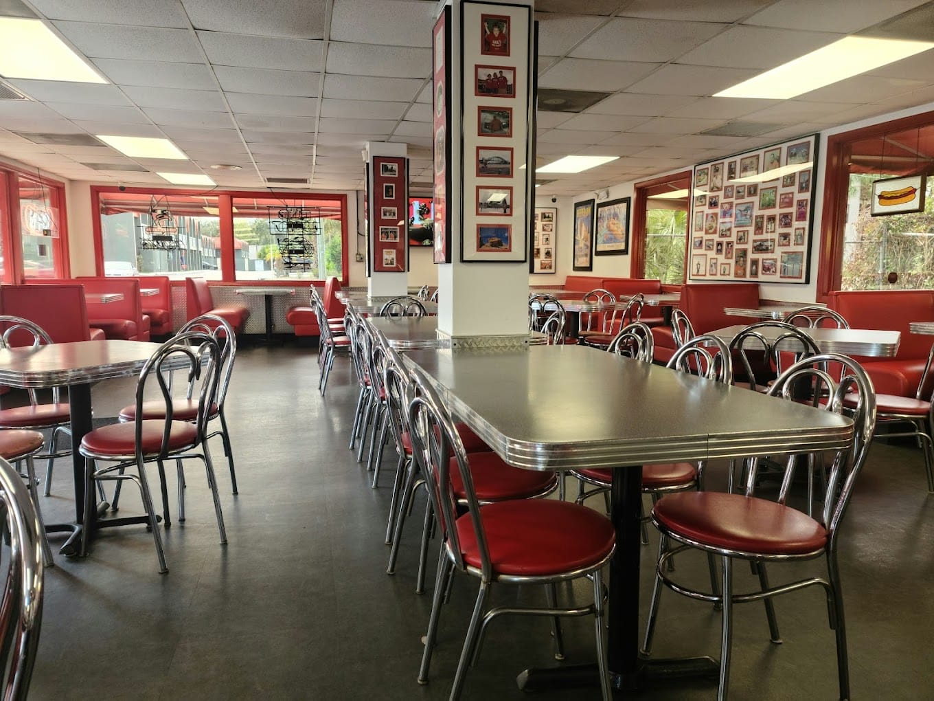 the interior of mels hot dogs featuring retro style red seating and a collection of framed pictures on the walls