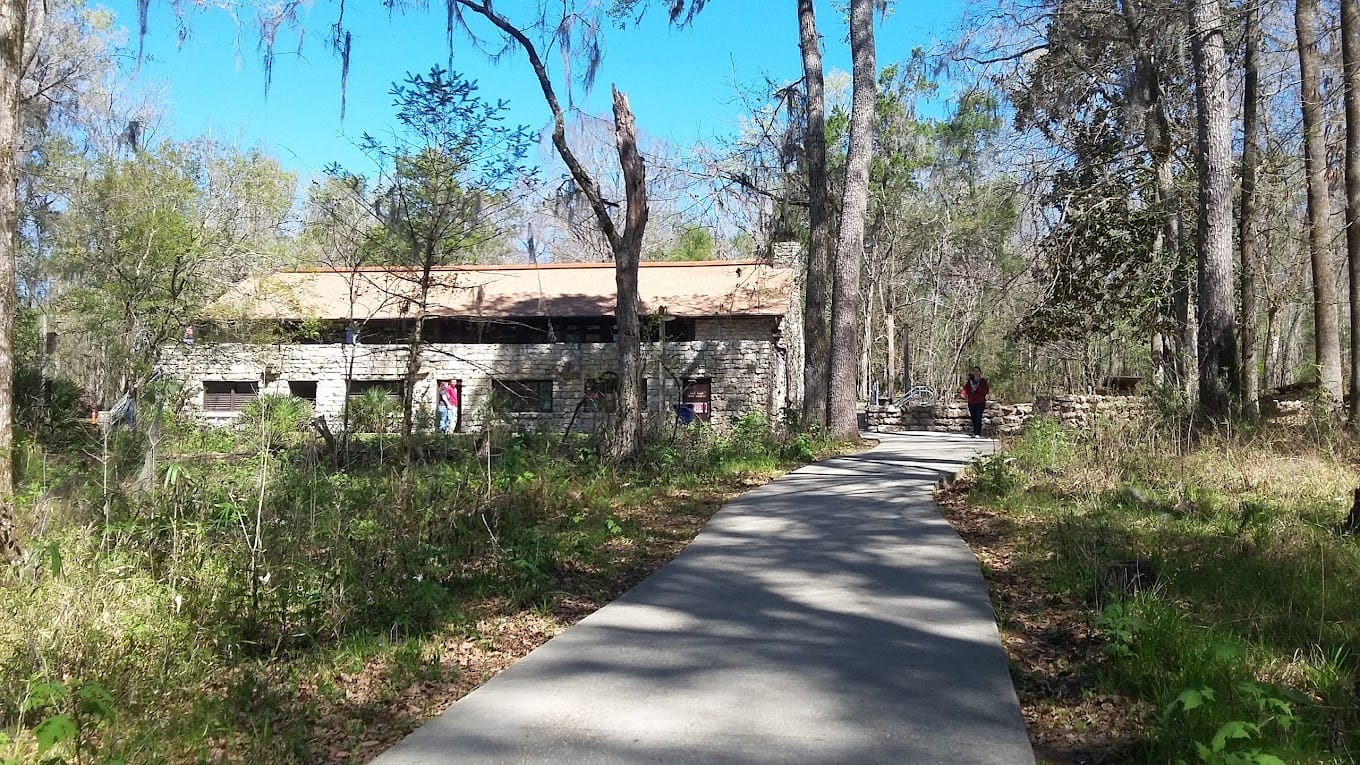 the visitor center at florida caverns state park nestled within a forested area and accessible by a paved pathway