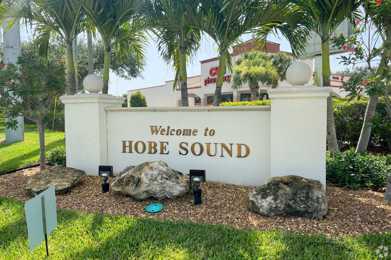 welcoming sign to hobe sound surrounded by lush greenery