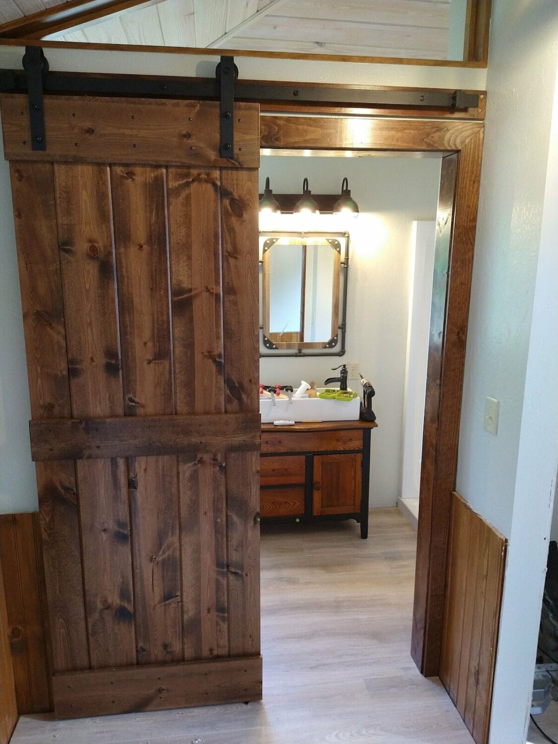 wooden door leading to the clean and spacious bathroom