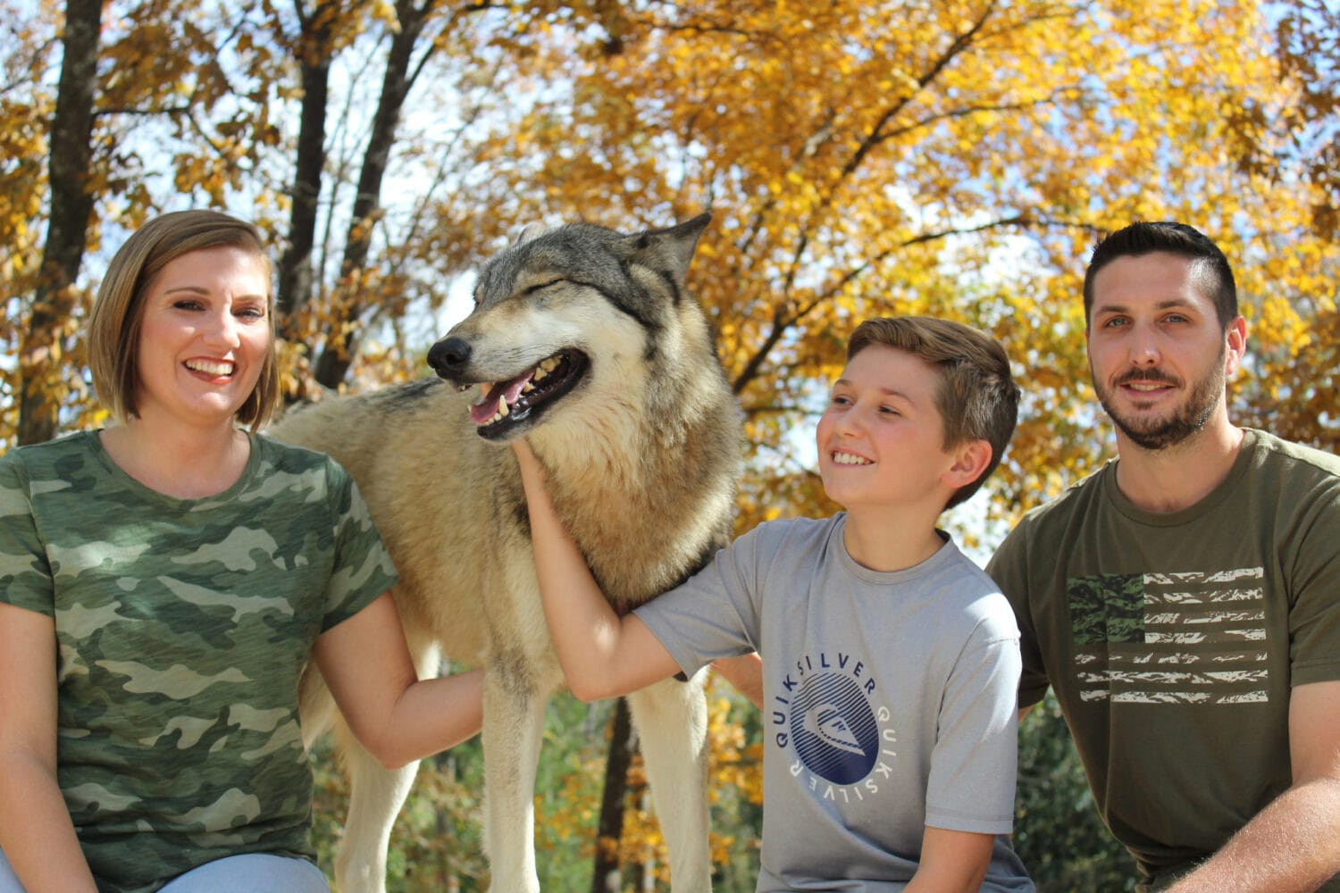 a family posing with a wolf at Chipley at the Seacrest Wolf Preserve