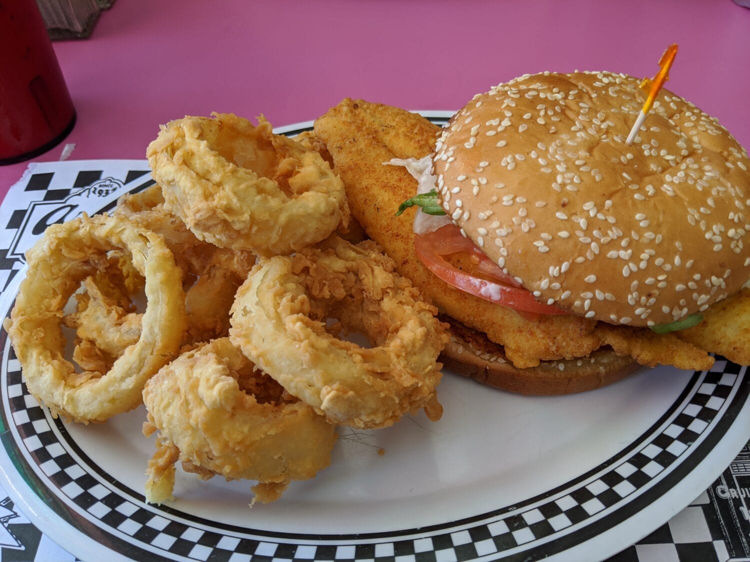 A plate of a loaded burger and crispy fired onion rings