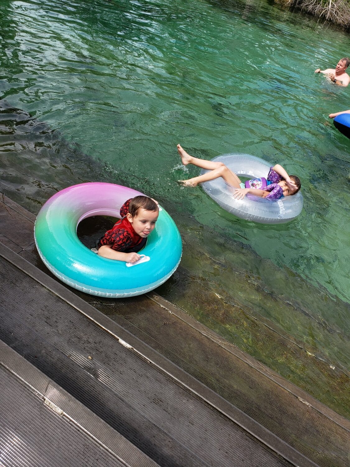 children on floaties enjoying a swim in the spring