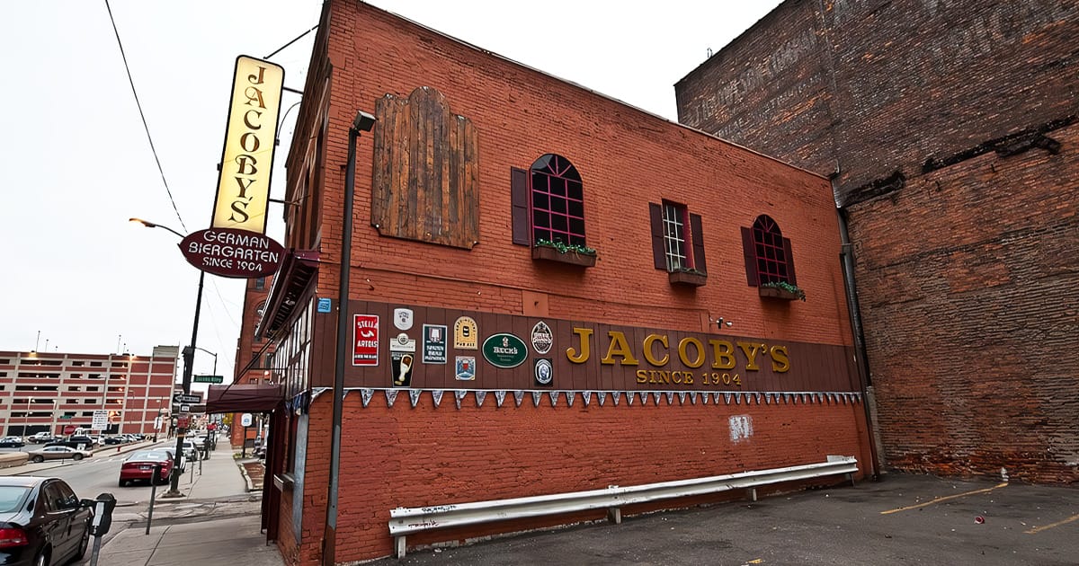 the exterior of jacoby's german biergarten, an enduring brick building with a vintage sign