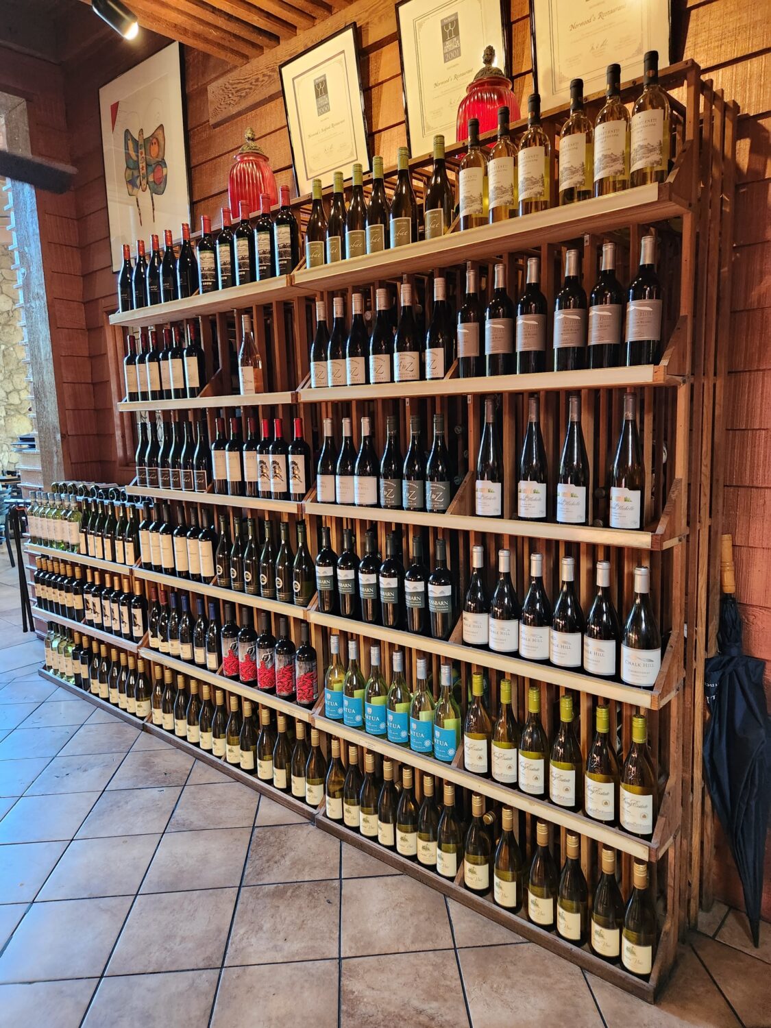 A shelf full of wines offered in the restaurant.