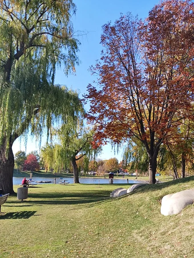 Weeping willows frame this peaceful scene, where benches invite visitors to pause and contemplate the surrounding beauty.