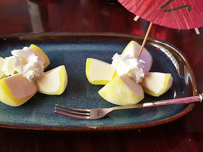 Simple elegance on a plate: fresh fruit arranged like flower petals, topped with clouds of whipped sweetness.