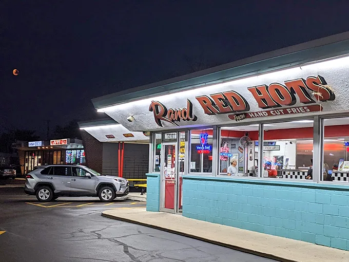 When the sun goes down, the neon lights up! This nighttime view of Rand Red Hots isn't just inviting, it's downright mesmerizing. Late-night cravings, anyone?