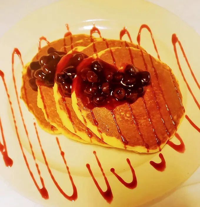 Pancakes so fluffy, they might float away! Studded with juicy blueberries and drizzled with syrup, they're a sweet dream come true.