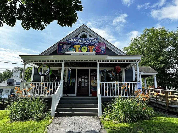 A charming blue-gray cottage with white trim beckons visitors inside, its whimsical "Once Upon A Time Toys" sign promising magical adventures ahead.