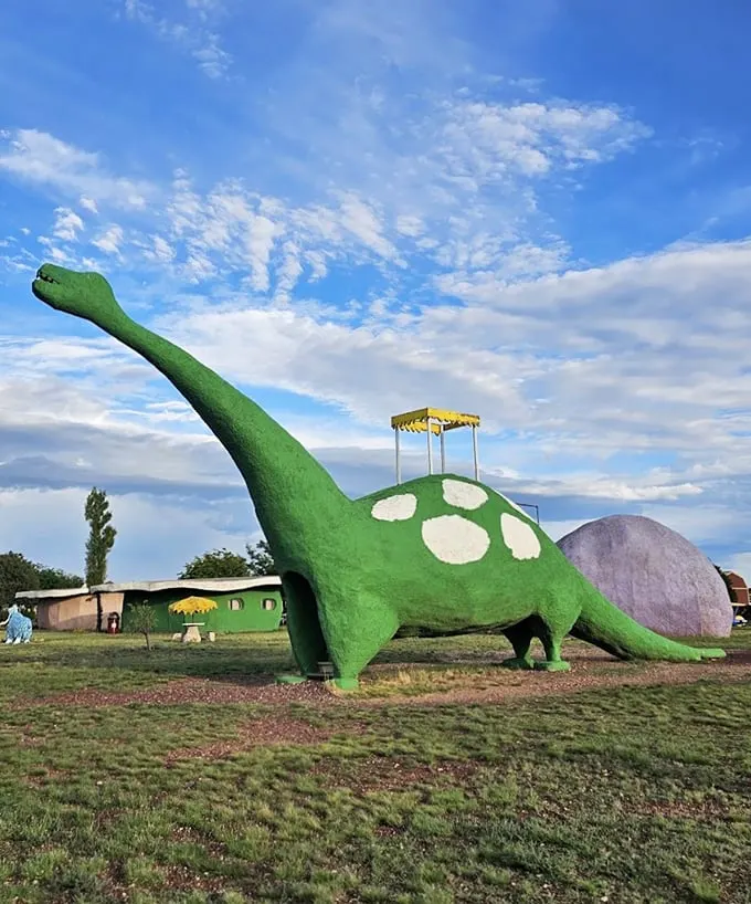 A friendly green dinosaur stands guard, complete with polka dots and a viewing platform—prehistoric fun meets modern whimsy.